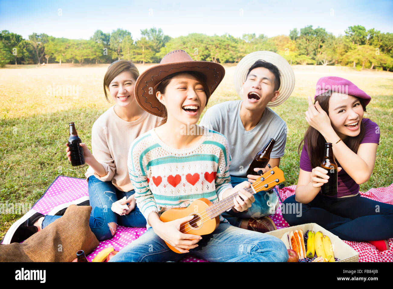 happy young friends enjoying picnic and playing ukulele Stock Photo - Alamy