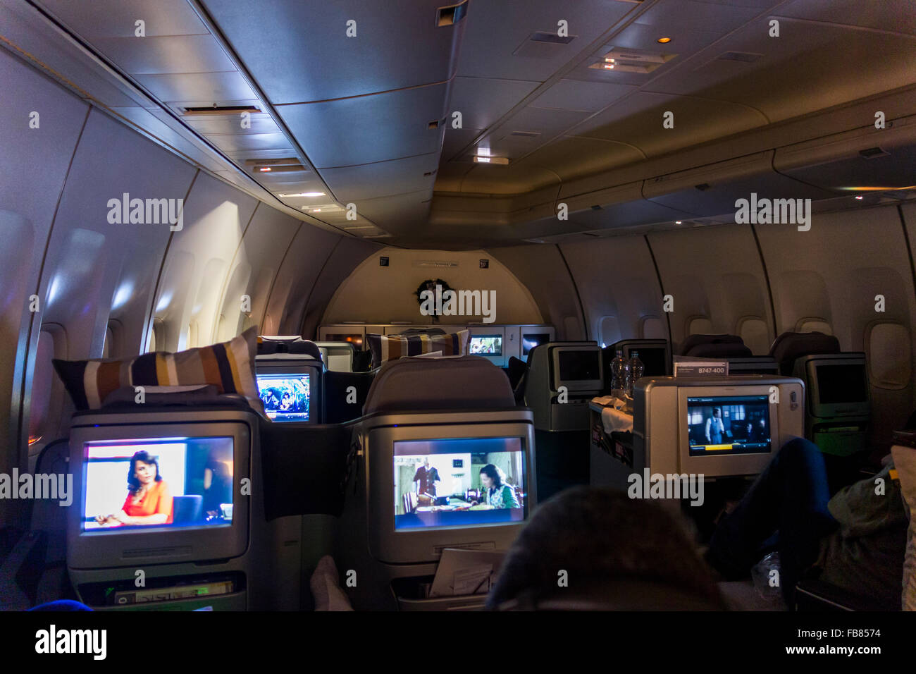 passengers in business class cabin watching entertainment screens ...