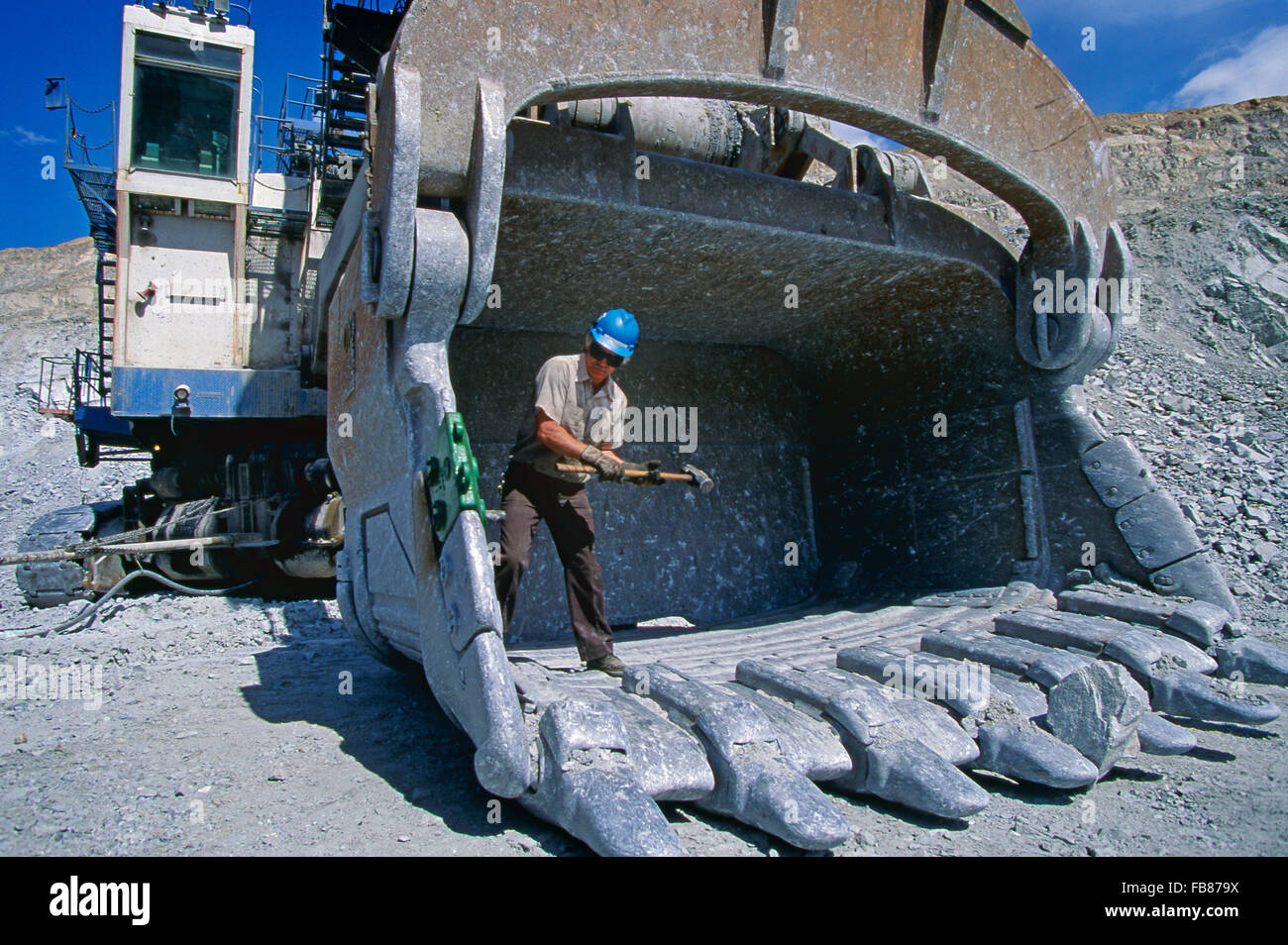 A heavy equipment mechanic repairs the shovel bucket of a giant ore ...
