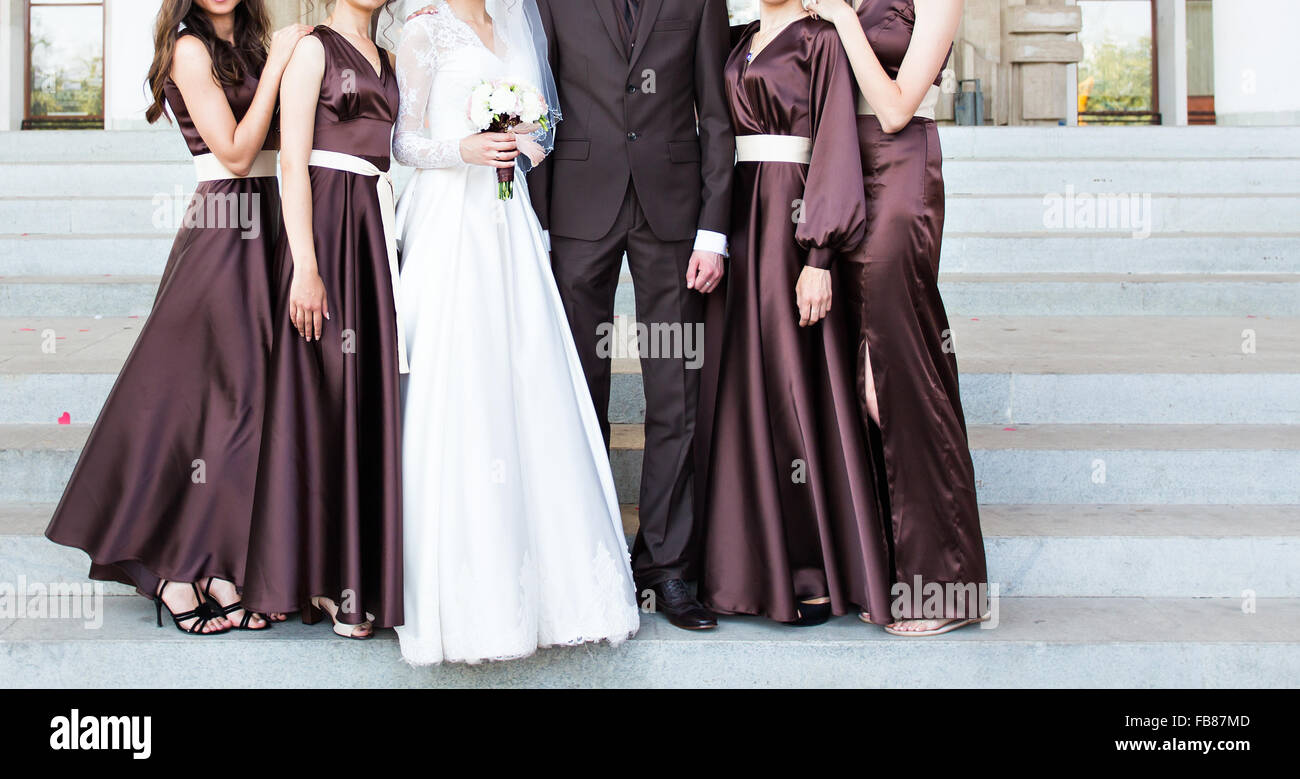 Handsome groom in suit hugging elegant bride with bridesmaids Stock ...