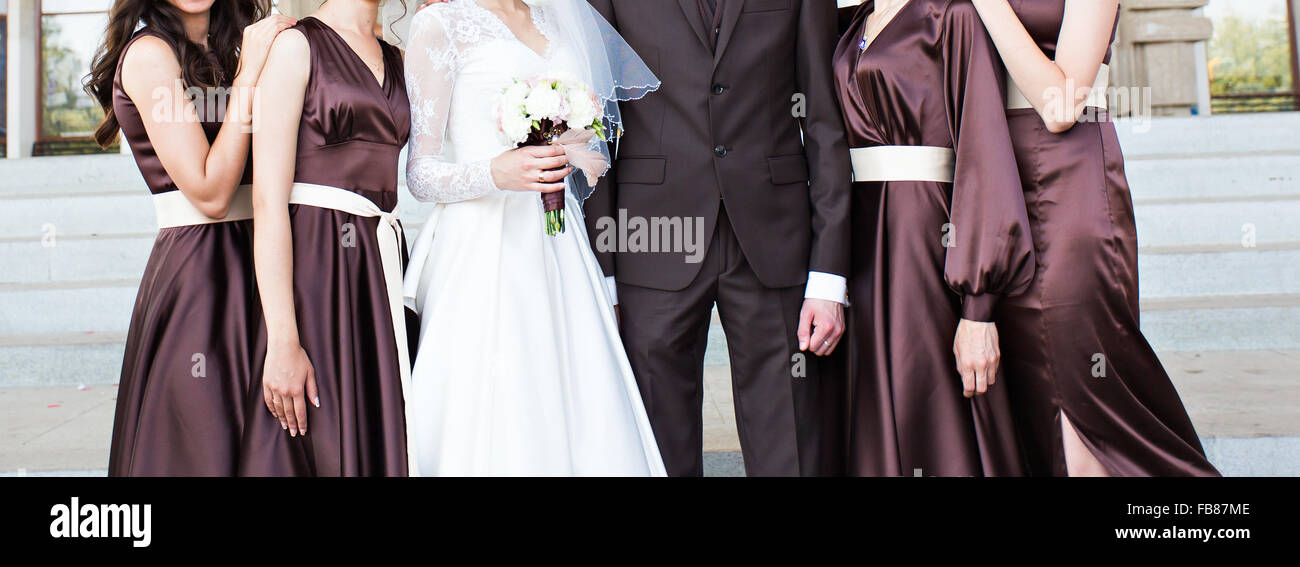 Handsome groom in suit hugging elegant bride with bridesmaids Stock ...