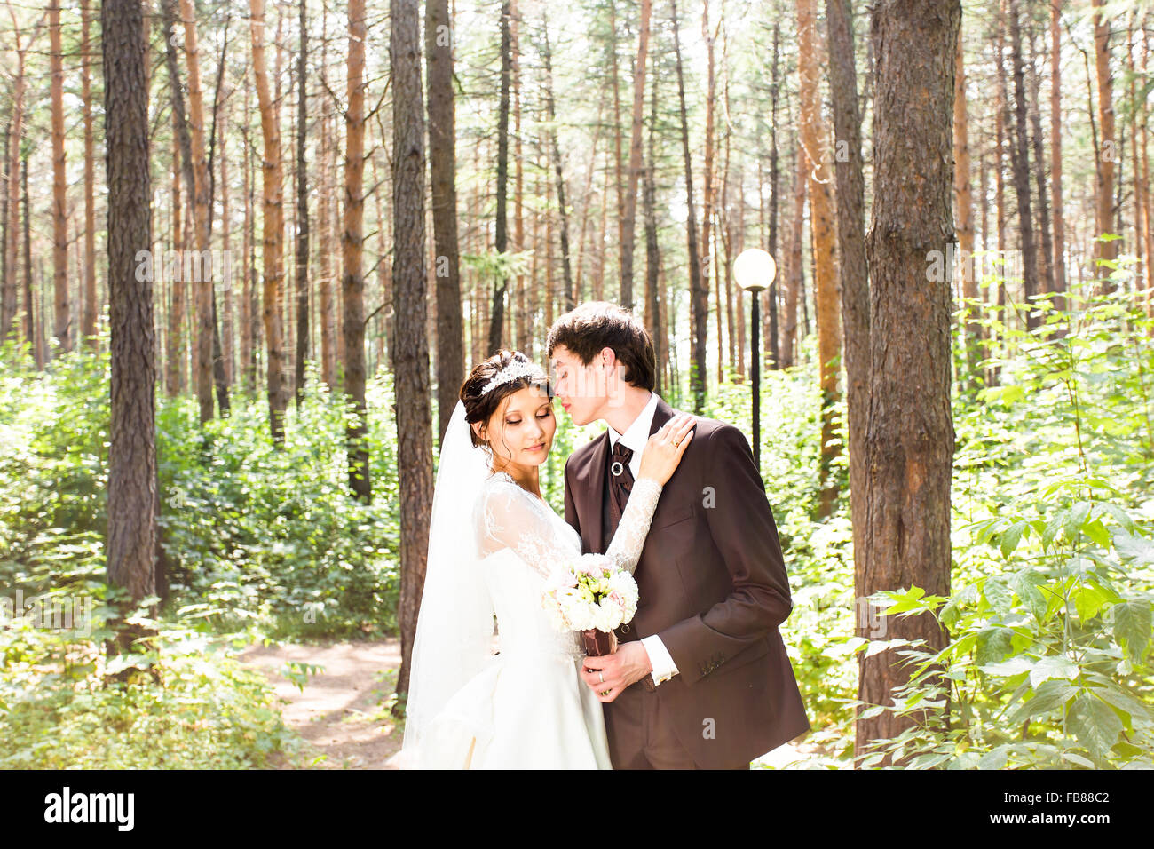 wedding couple hugging, the bride holding a bouquet of flowers in her ...