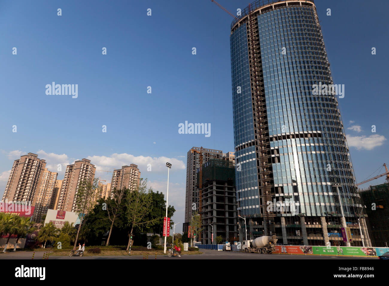 Workers affix glass panes to a 200-metre-high office tower as other ...