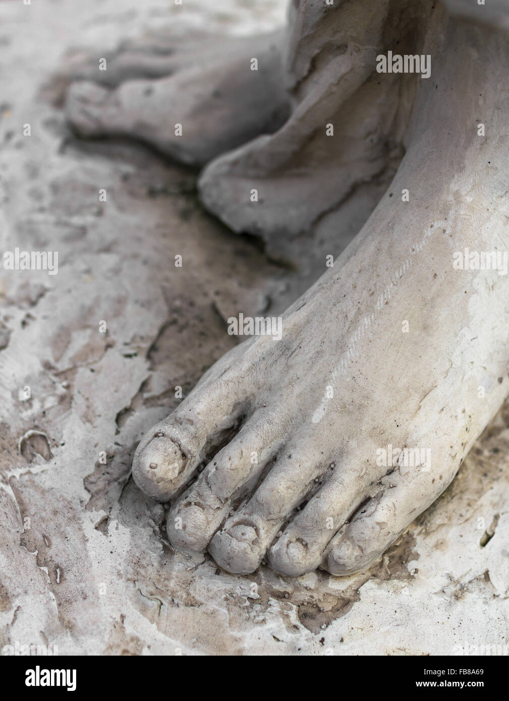 Detail of a marble statue, depicting the foot of the suffering Christ ...