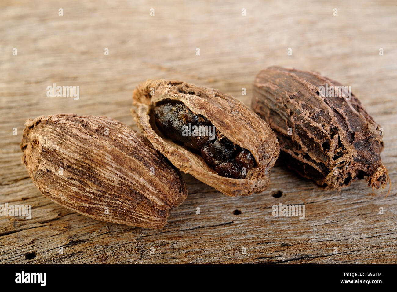 black cardamom on wooden background Stock Photo - Alamy