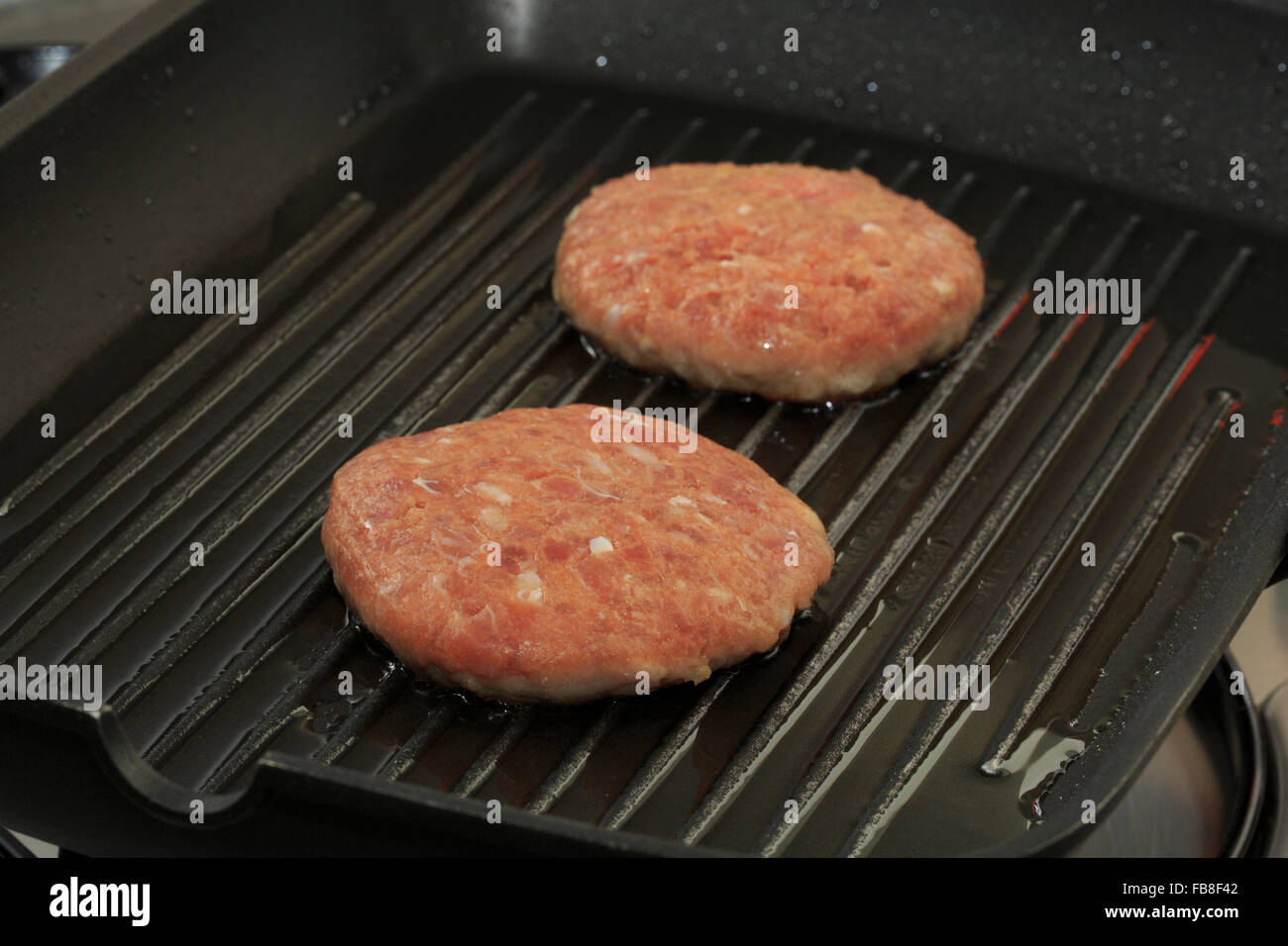 Burgers cooking in a griddle Stock Photo - Alamy