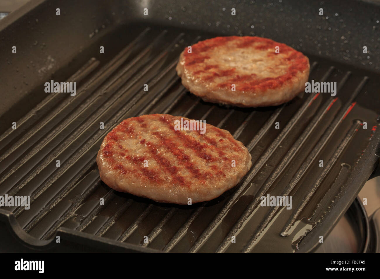 Burgers cooking in a griddle Stock Photo - Alamy