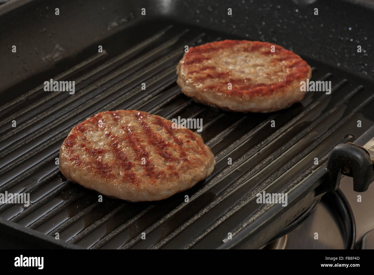 Burgers cooking in a griddle Stock Photo - Alamy