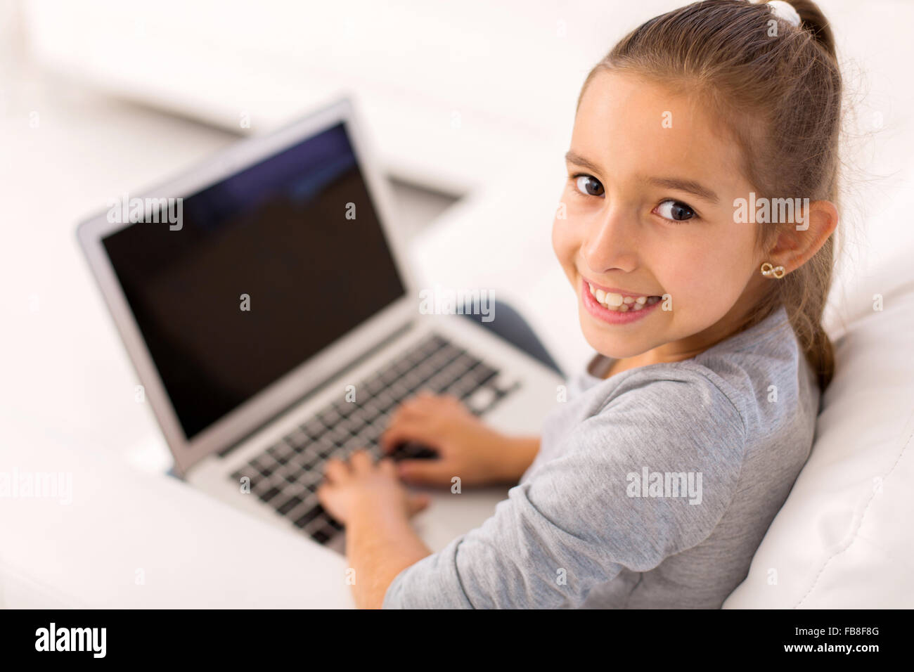 pretty little girl with laptop computer looking back Stock Photo - Alamy