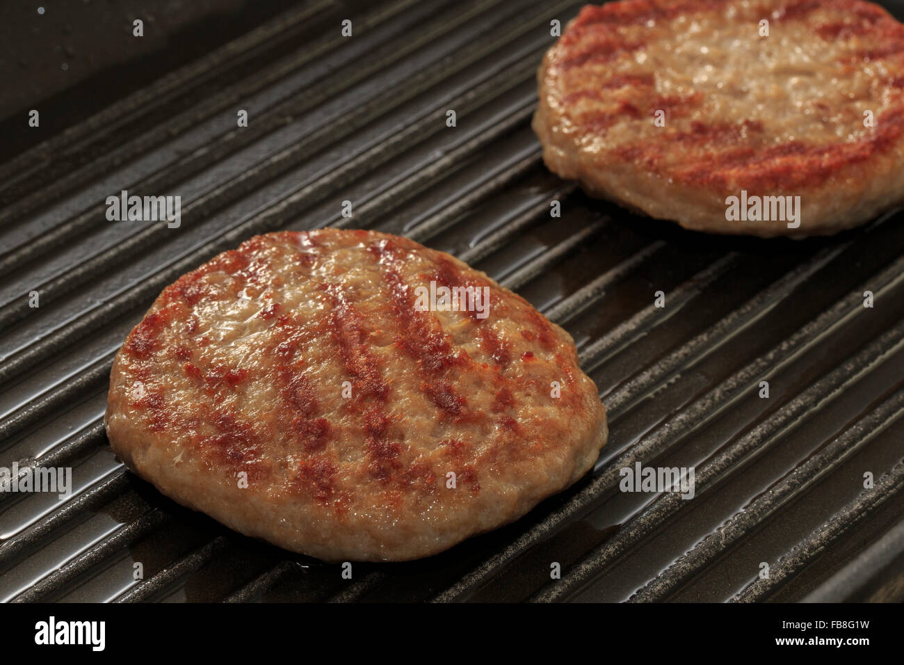 Burgers cooking in a griddle Stock Photo - Alamy
