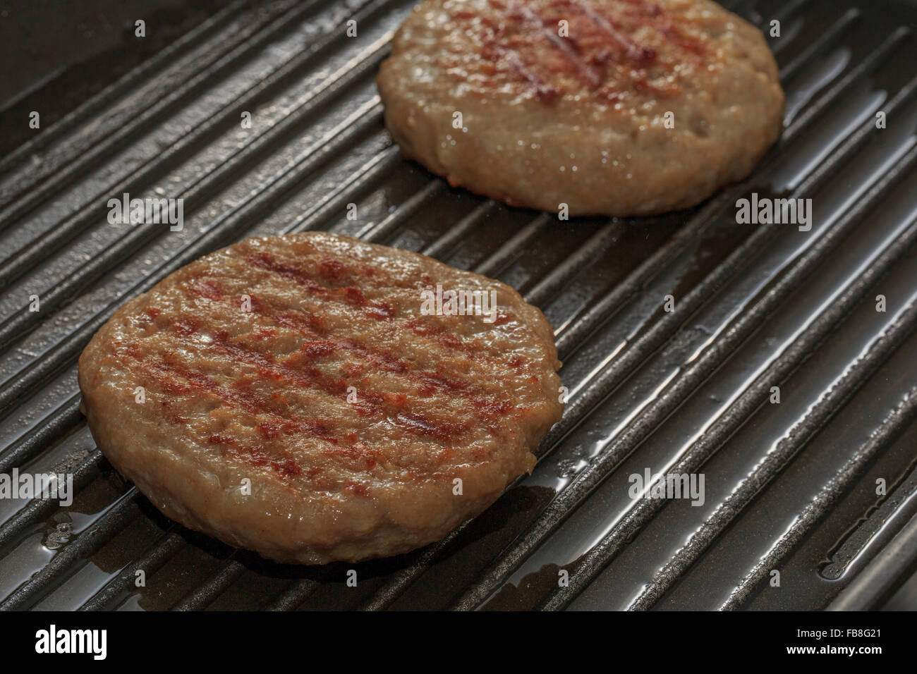 Burgers cooking in a griddle Stock Photo - Alamy