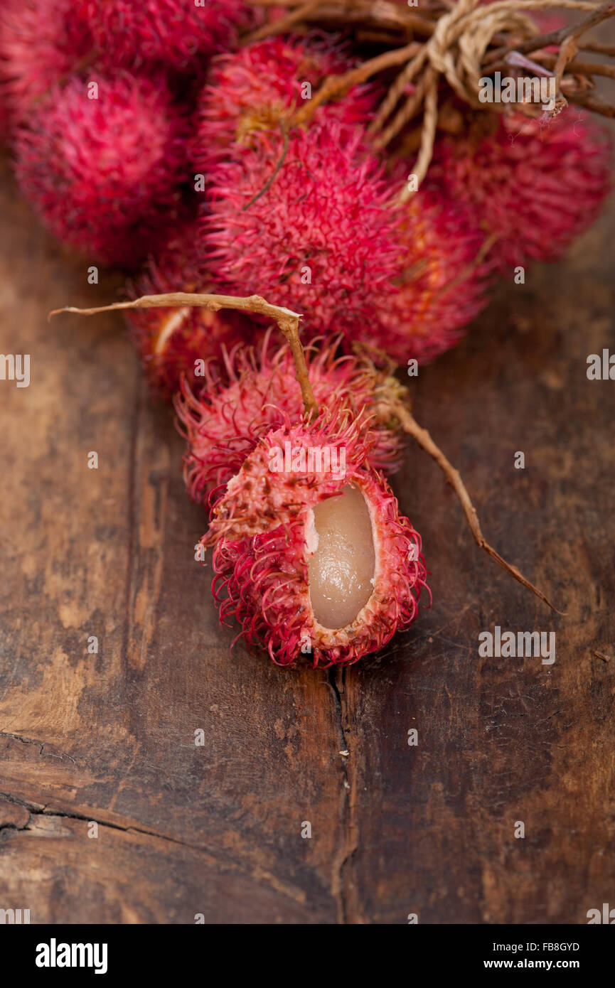 fresh tropical rambutan fruits over rustic wood table Stock Photo - Alamy