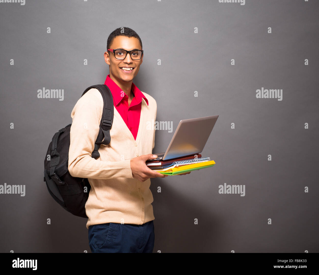Handsome latin student with laptop computer in studio Stock Photo - Alamy