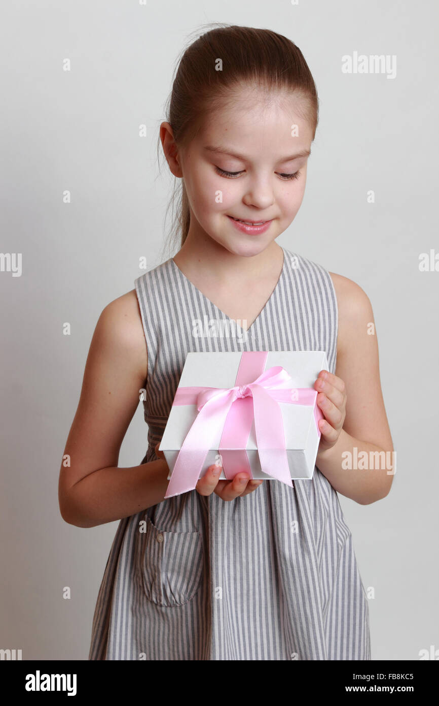 Lovely smiley little girl holding white gift box with pink ribbon Stock ...