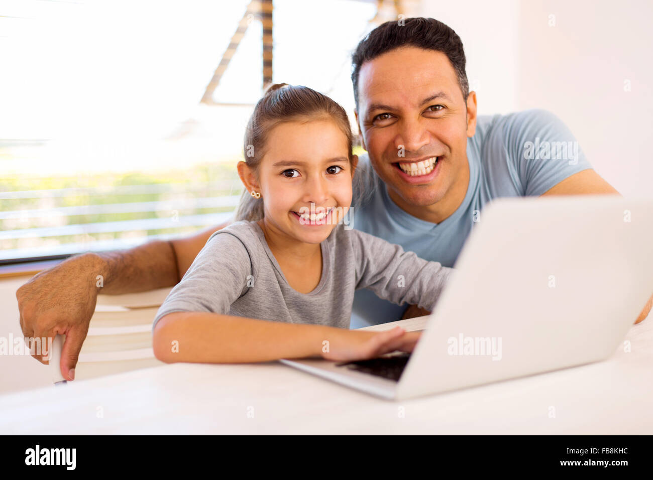 cheerful father and daughter using laptop computer at home Stock Photo ...