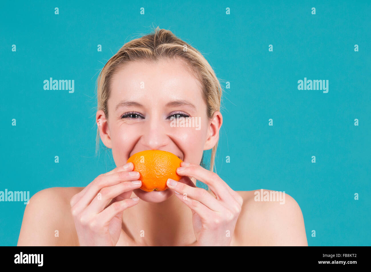 Healthy woman eating fresh orange fruit Stock Photo - Alamy