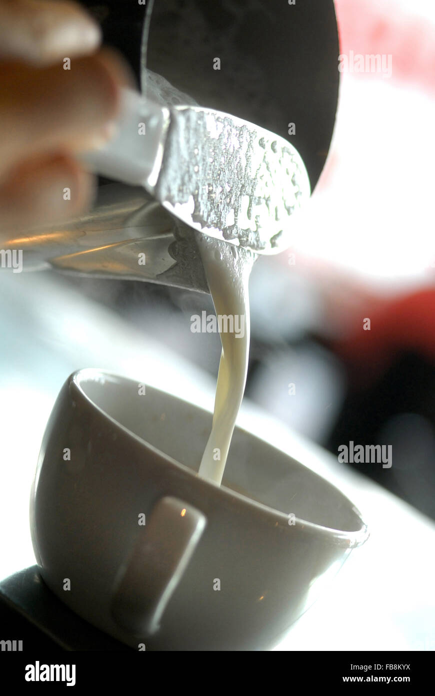 Pouring hot milk into coffee Stock Photo - Alamy