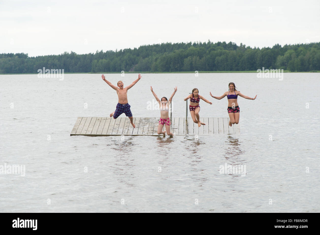 Boy jumping from diving platform hi-res stock photography and images ...