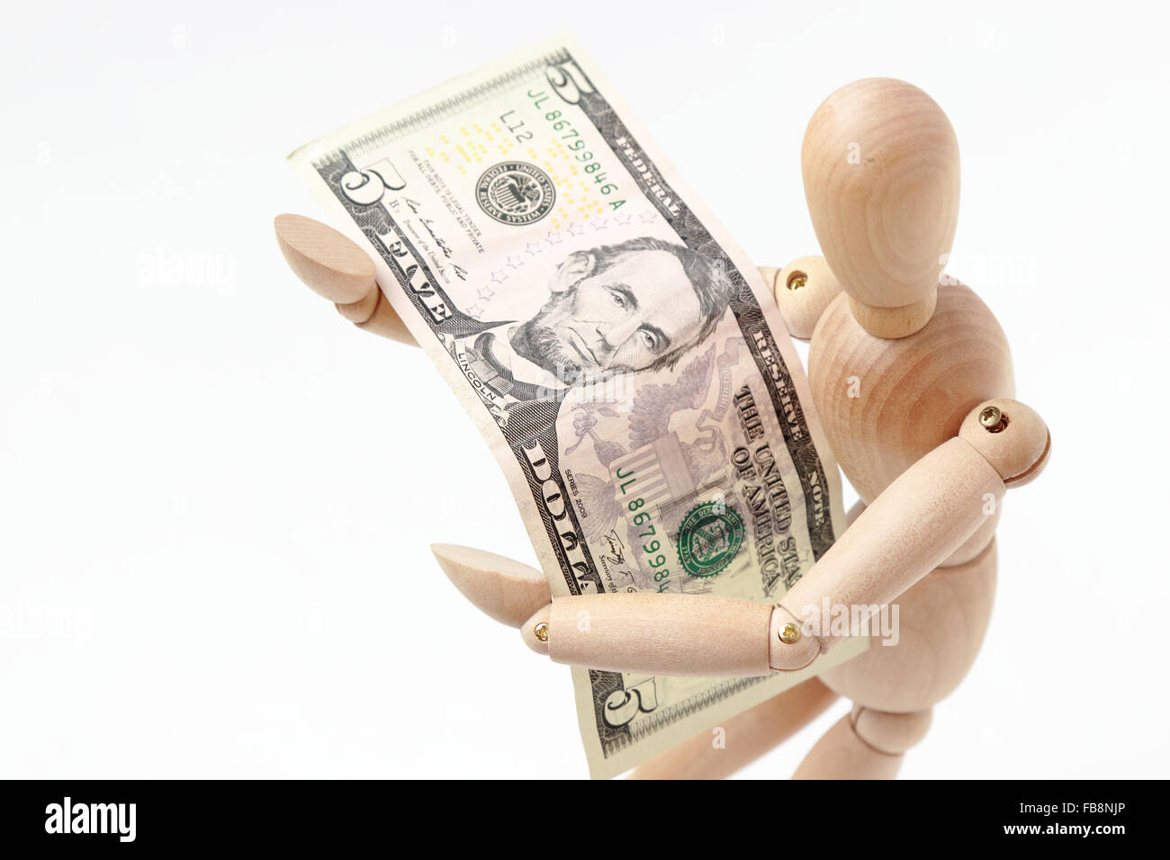 Wooden man toy and dollars Stock Photo - Alamy