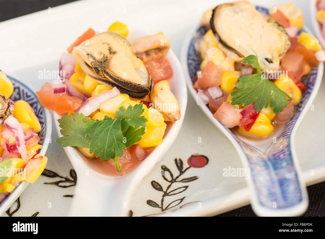 Peruvian ceviche made with mussels on ceramic serving spoons Stock ...