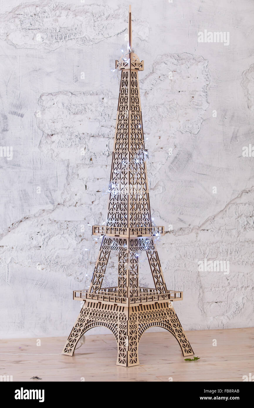 figure of the Eiffel Tower on a floor in the light room against a wall ...