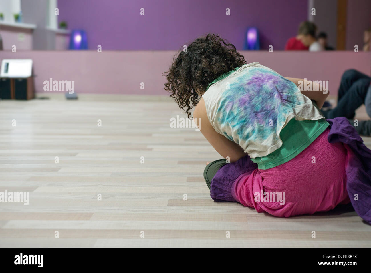 Brunette woman sitting on the floor in the hall Stock Photo - Alamy