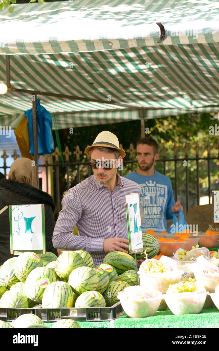 Man buying a melon at the fruit and vegetable market in Bedford ...