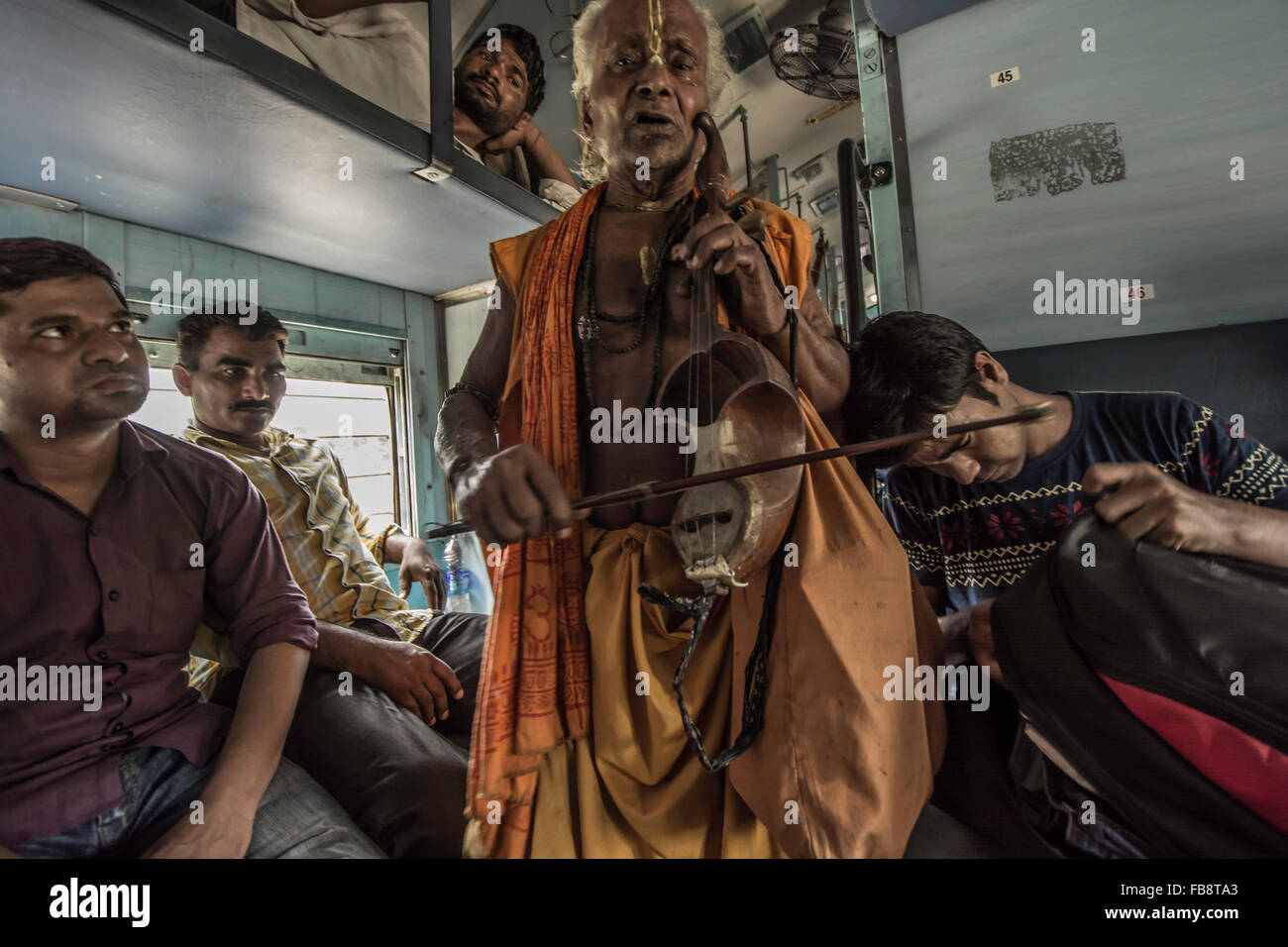 Traveling musician playing for passengers on an Indian train Stock ...
