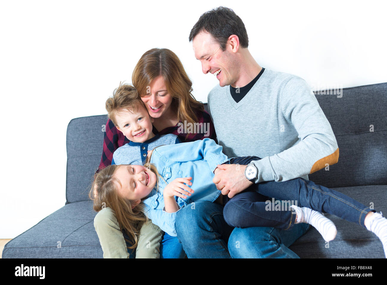 Nice family sit on the livingroom sofa Stock Photo - Alamy