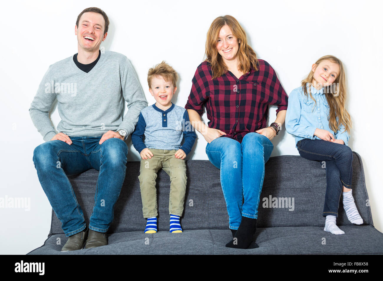Nice family sit on the livingroom sofa Stock Photo - Alamy