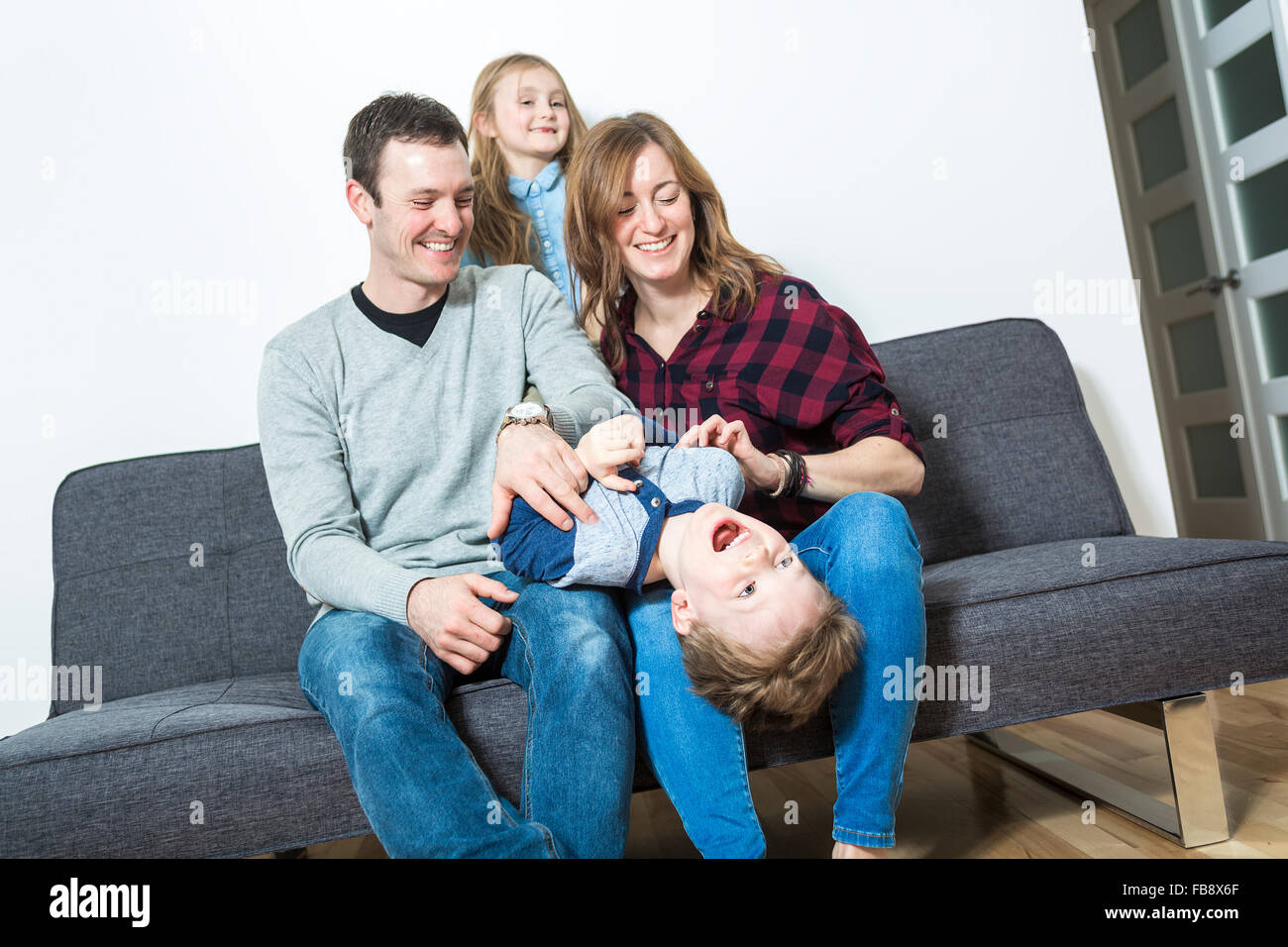 Nice family sit on the livingroom sofa Stock Photo - Alamy