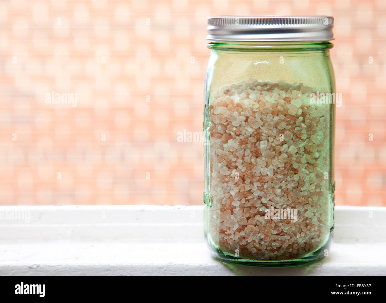Himalayan sea salt in green glass mason jar, on windowsill with brick ...