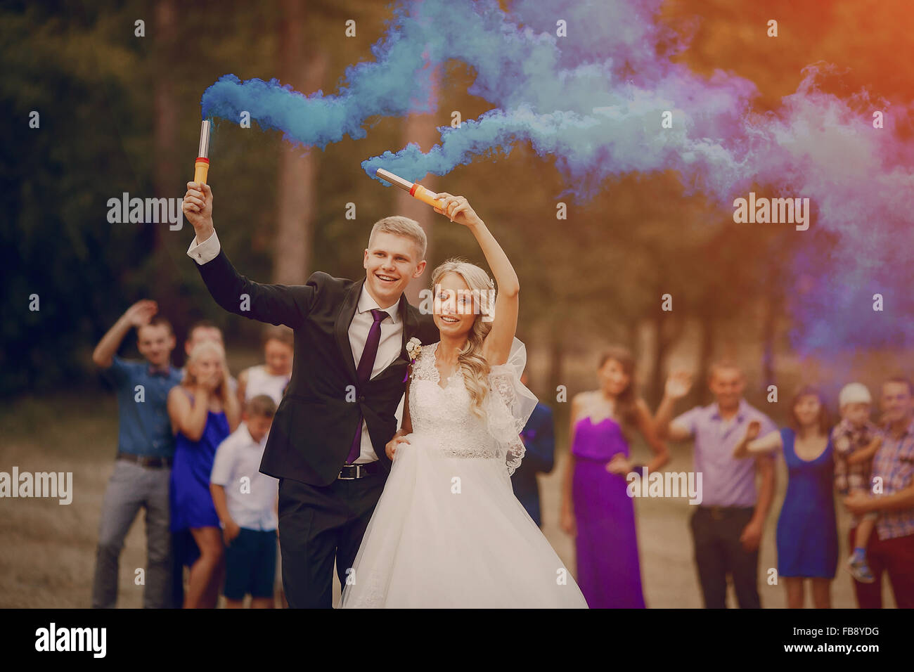Wedding couple runs blue smoke Stock Photo - Alamy
