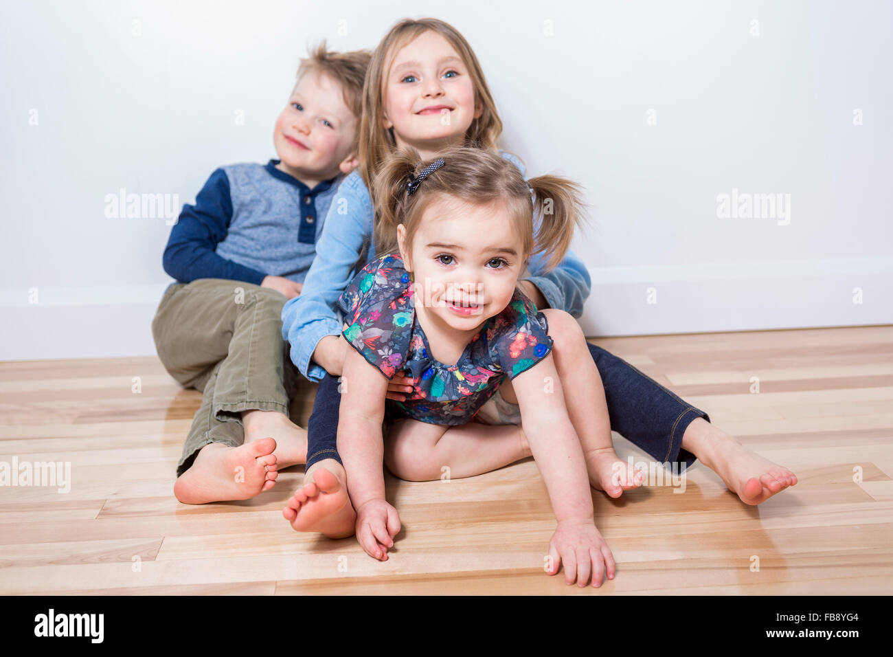 three child sit on the floor at home Stock Photo - Alamy