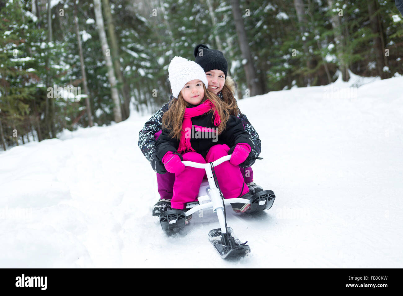 Two kids sliding with sledding Stock Photo - Alamy