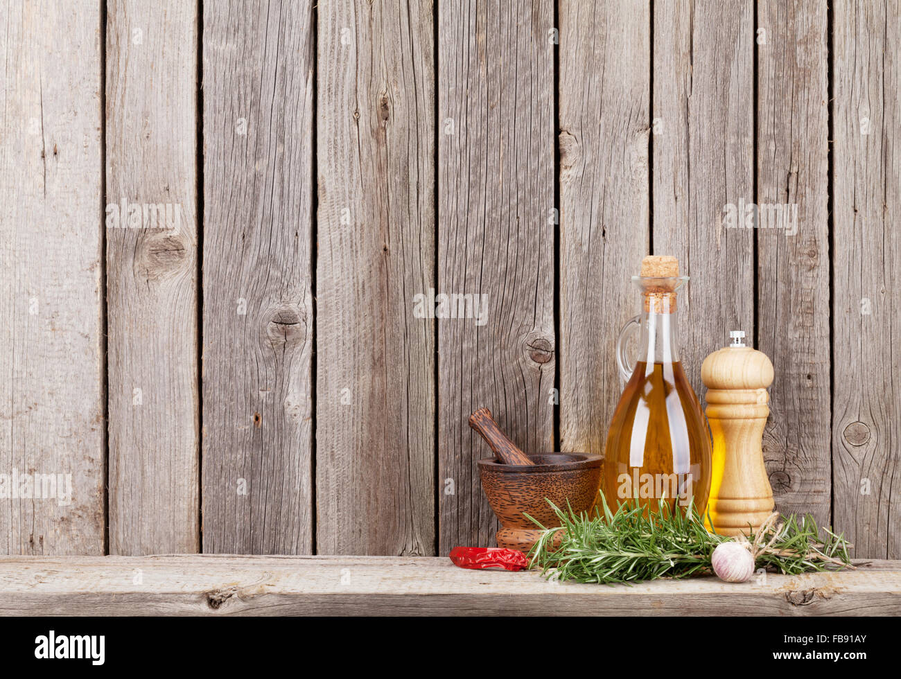Kitchen utensils, herbs and spices on shelf against rustic wooden wall ...