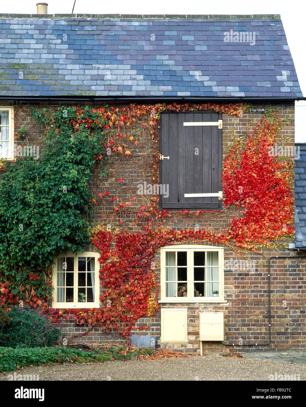 Exterior of a country cottage with door on the first floor and a wooden ...