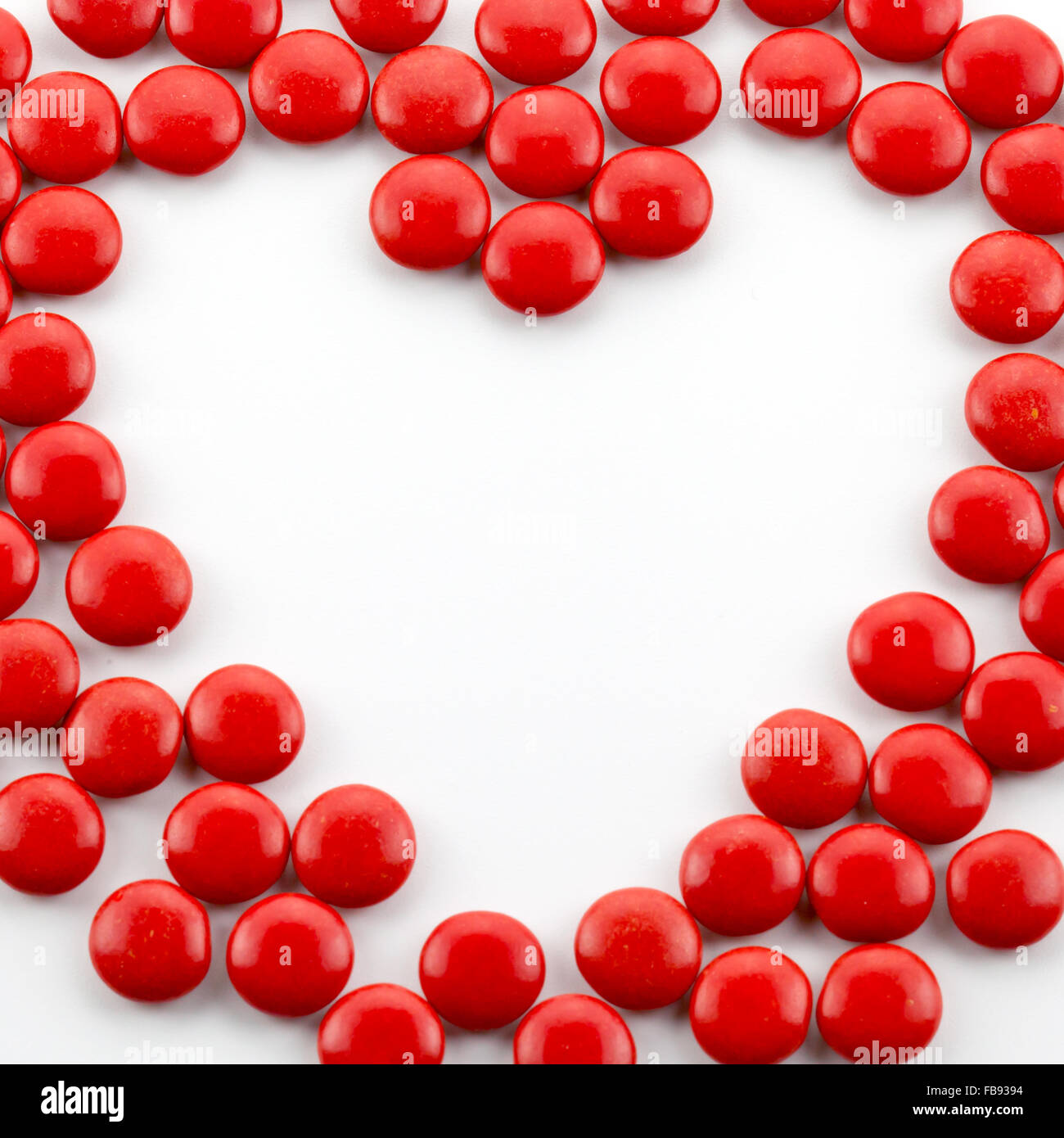 Heard made of red candies close up on white background Stock Photo - Alamy