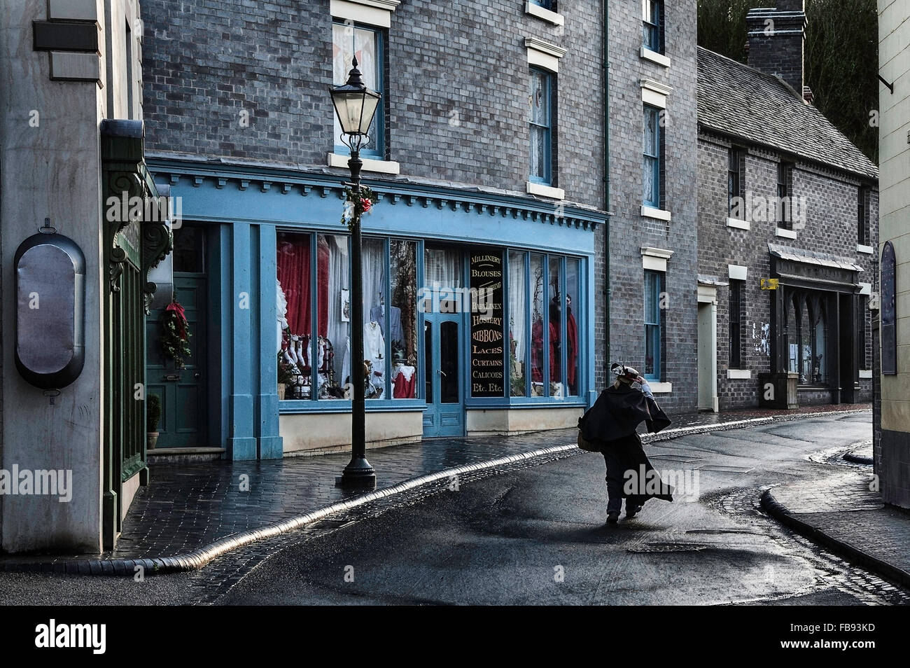 Rainy wind swept Victorian street with woman being blown by wind Stock ...