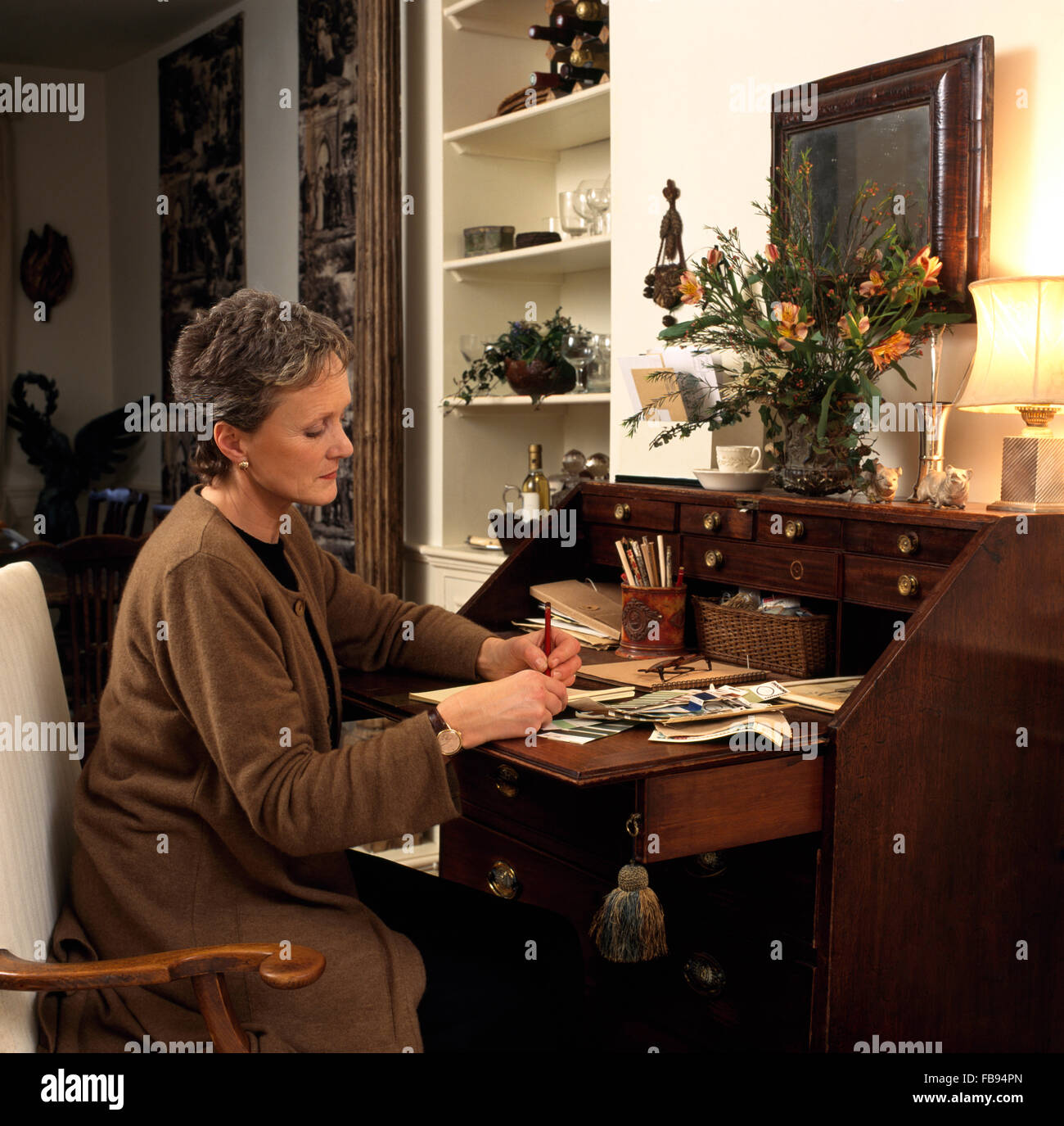 Woman sitting and writing at her desk FOR EDITORIAL USE ONLY Stock ...