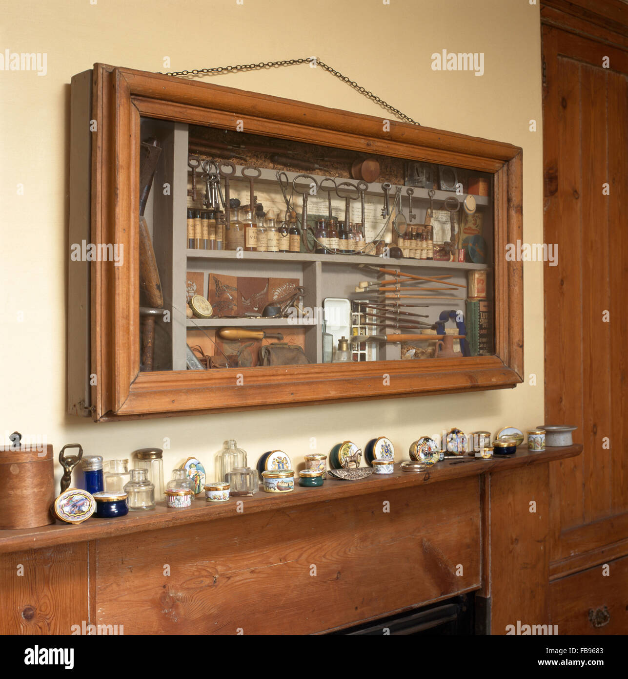 Collection of eclectic objects in glass frame above mantelpiece with a ...