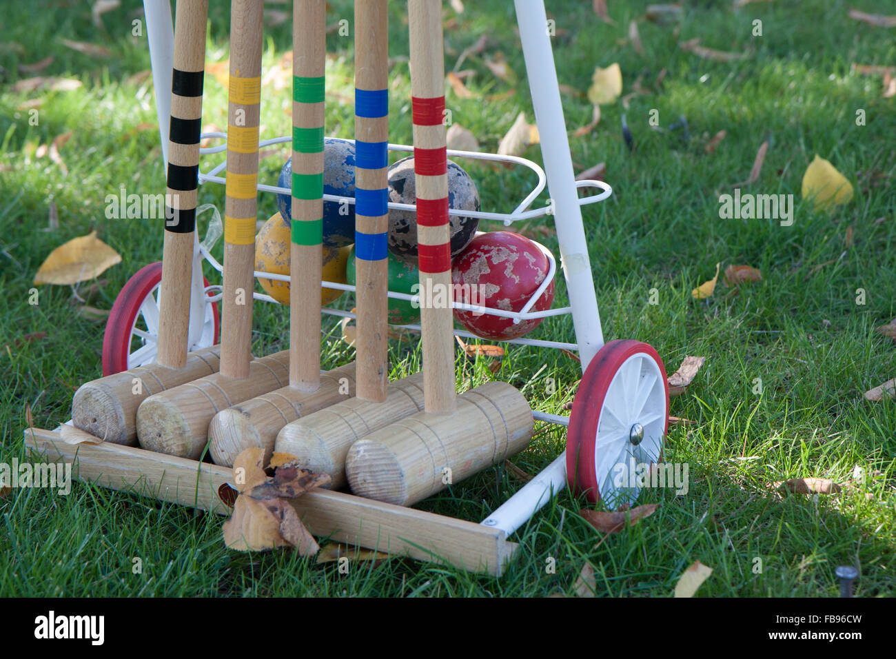 A set of wooden mallets and balls on a special trolley for a game of ...
