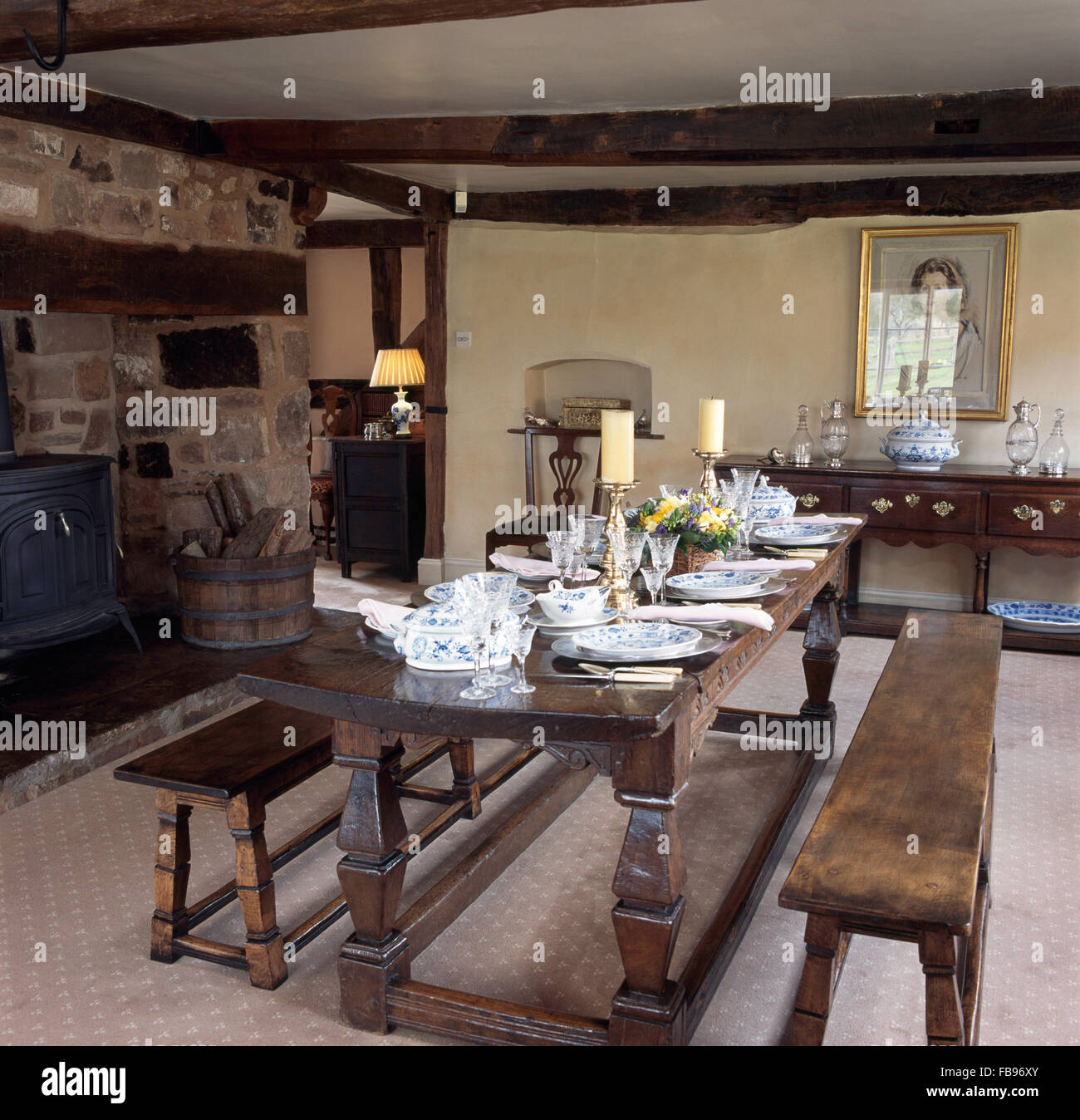 Rustic wooden benches at oak table set for lunch in traditional country ...