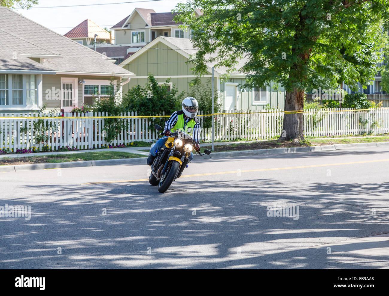 Pace motorcycle leading a Professional bicycle race through residential ...