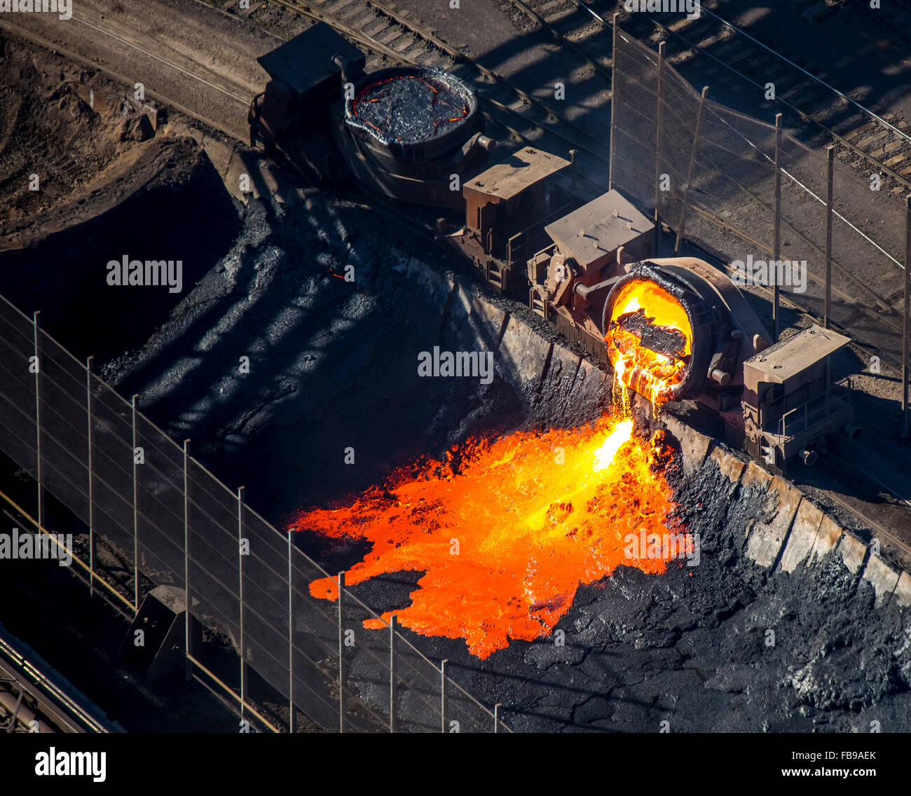 Aerial view, hot slag from the iron production is tipped from a torpedo ...