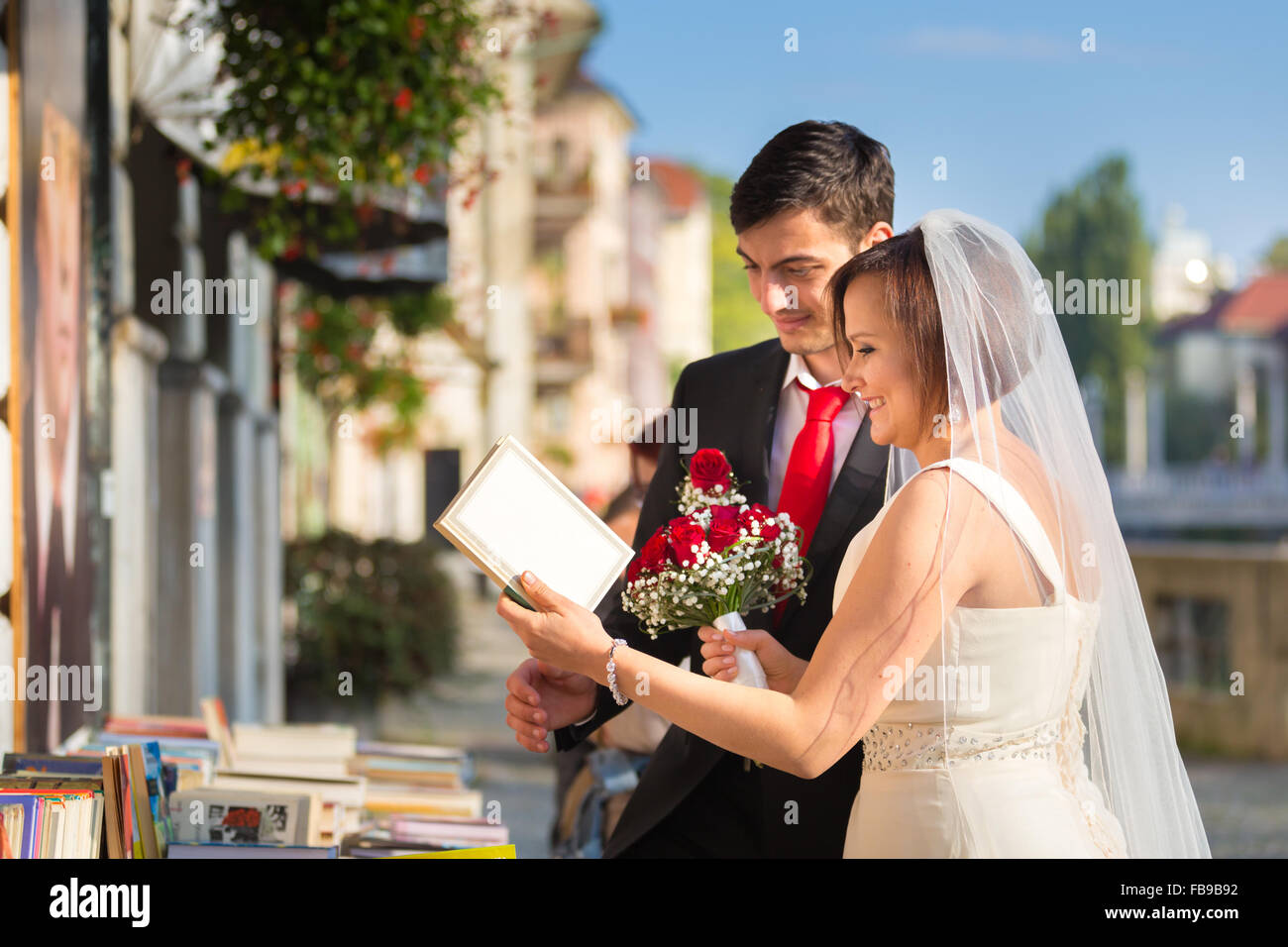 Beautiful wedding couple reviewing vintage books Stock Photo - Alamy