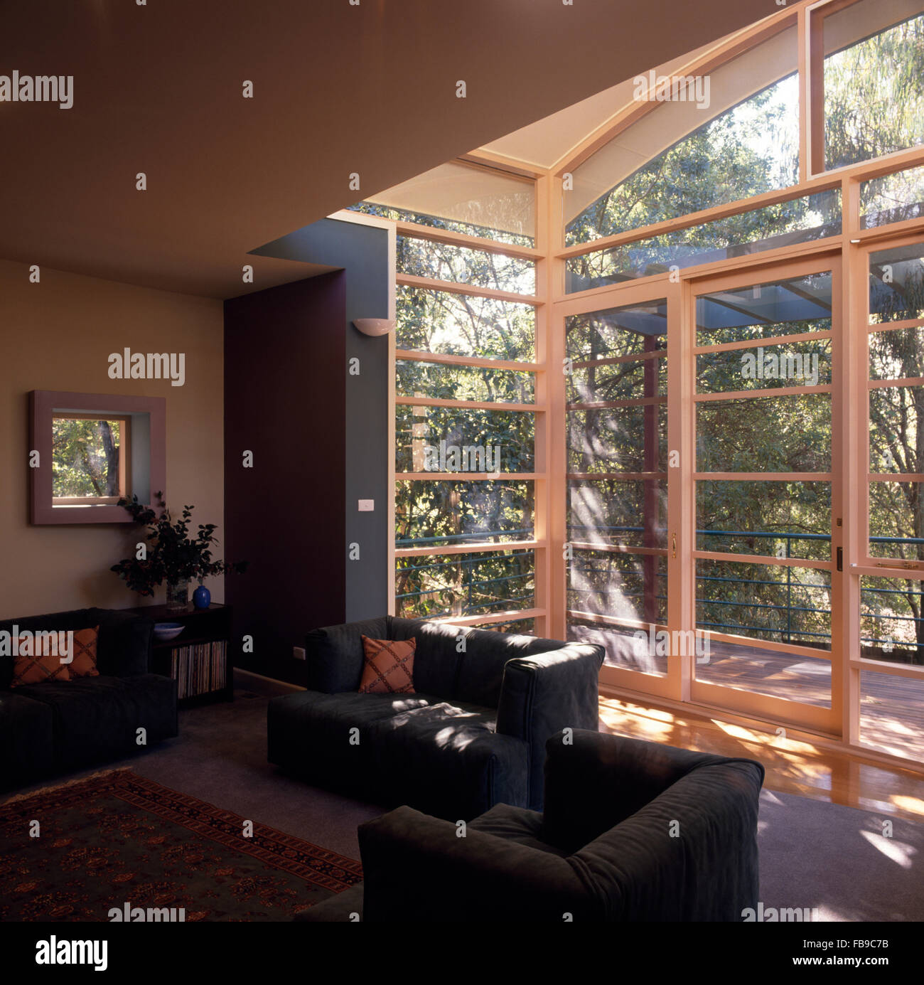 Angular gray armchair and sofas in an nineties living room with an ...