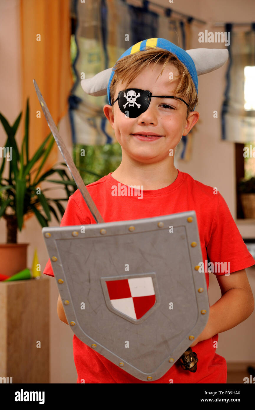 Boy dressed as viking with pirate's eye patch, sword and shield ...