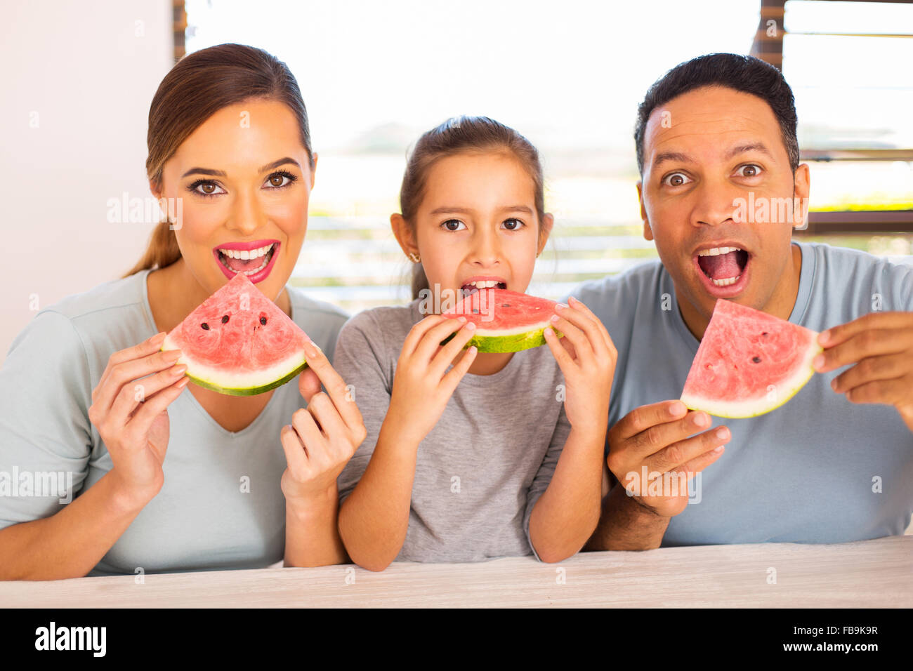 beautiful family of three eating watermelon Stock Photo - Alamy