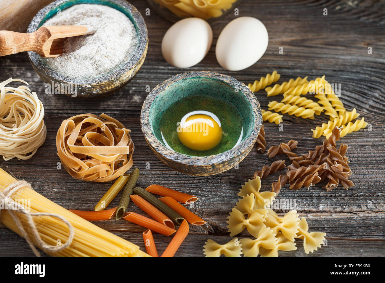 A set of raw pasta and addons on wooden table. Studio picture Stock ...